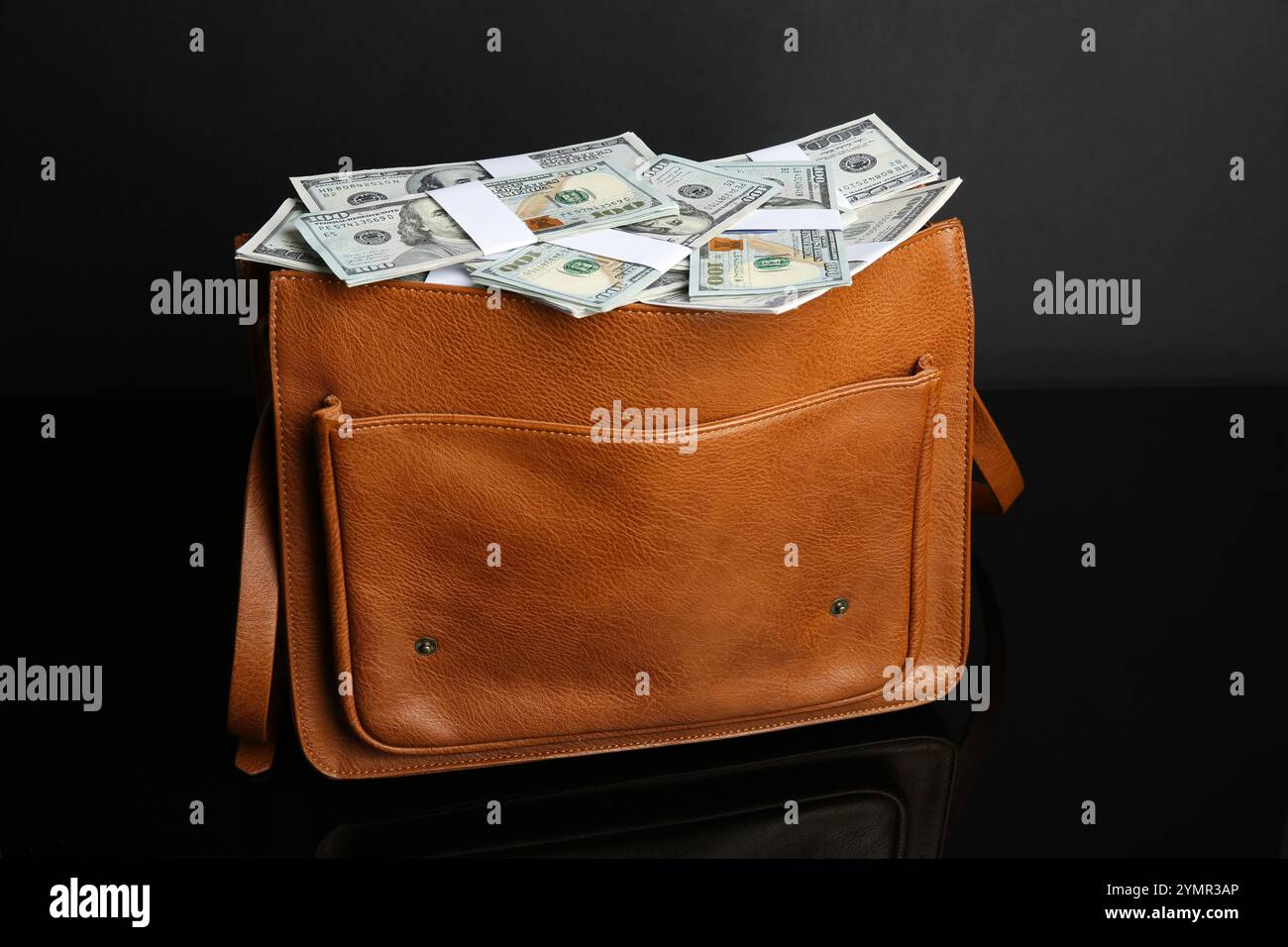 Dollar banknotes in leather bag on black mirror surface Stock Photo - Alamy