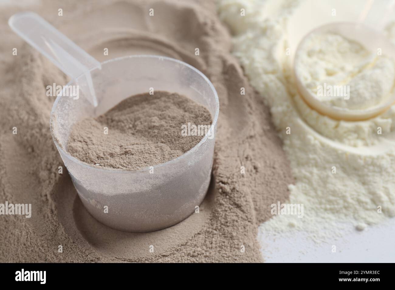 Protein powders and scoops on white background, closeup Stock Photo - Alamy