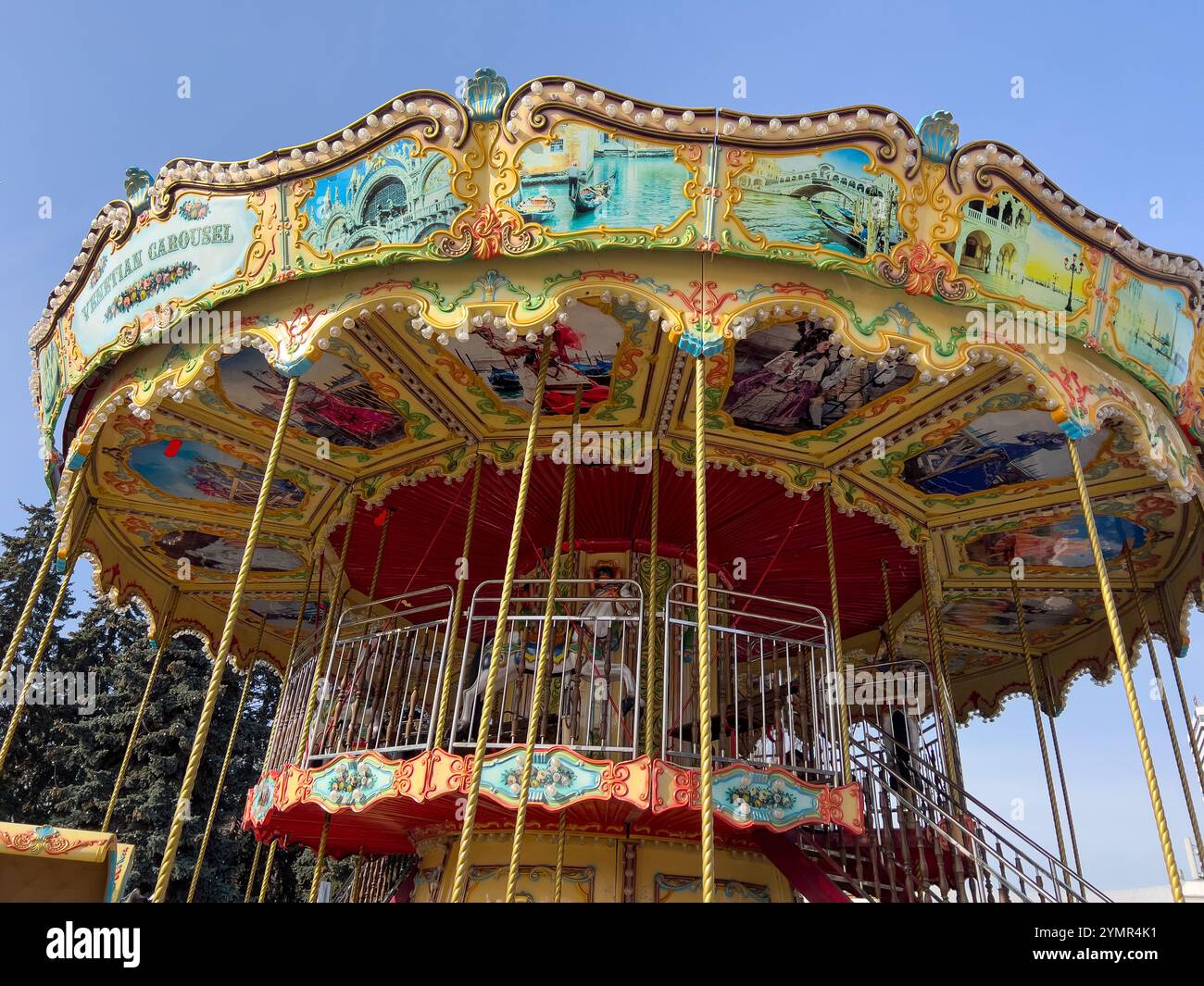 A colorful carousel with decorated horses and a two-tier structure ...
