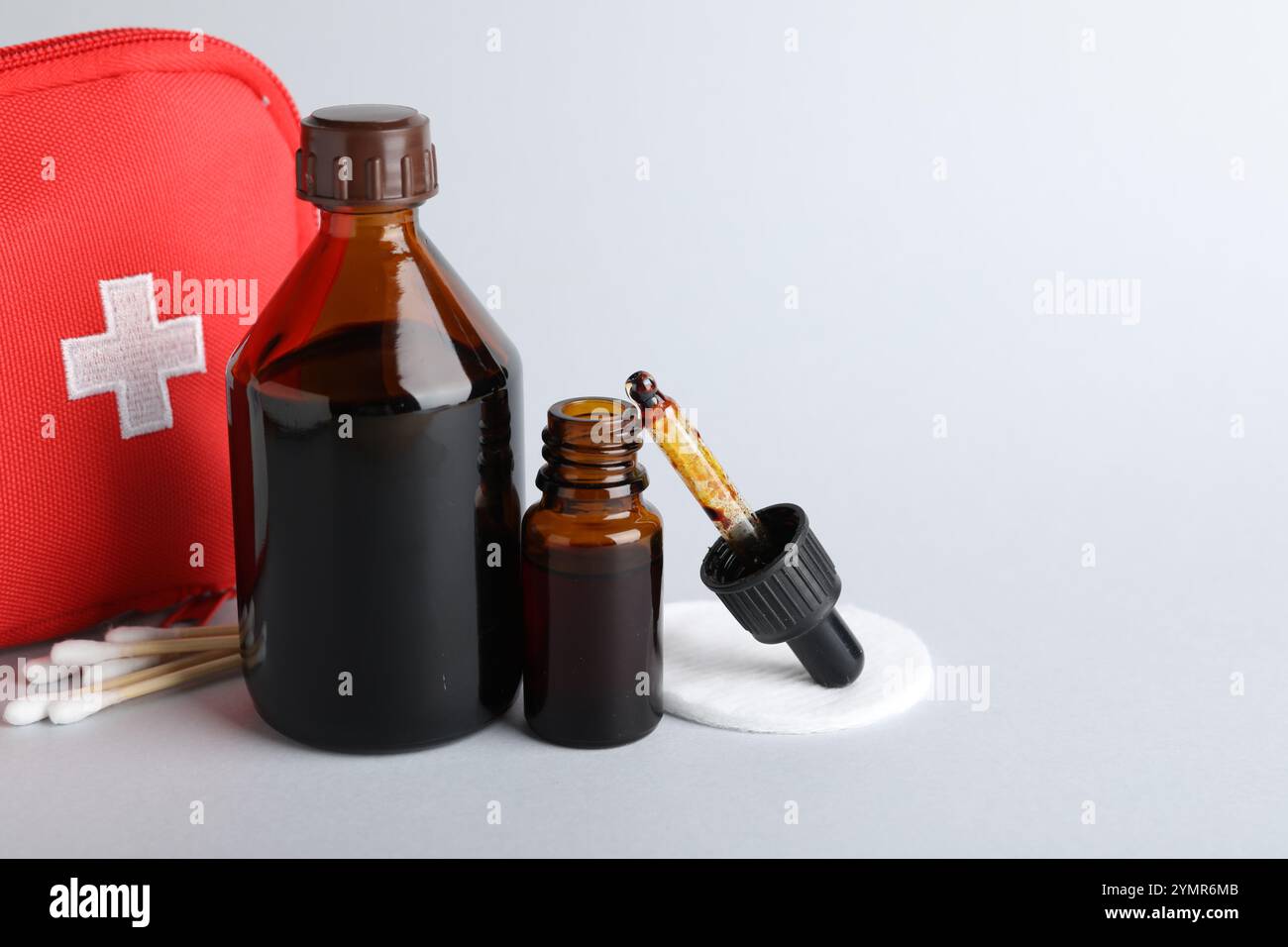 Topical iodine and other first aid kit components on light background ...