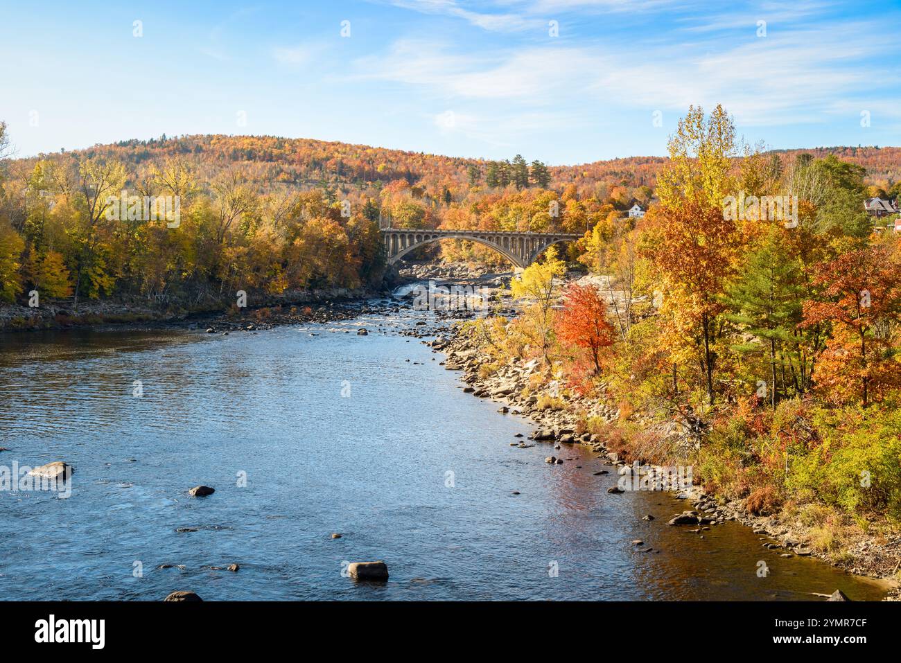 Arch road bridge spanning a river winding its way through forested ...