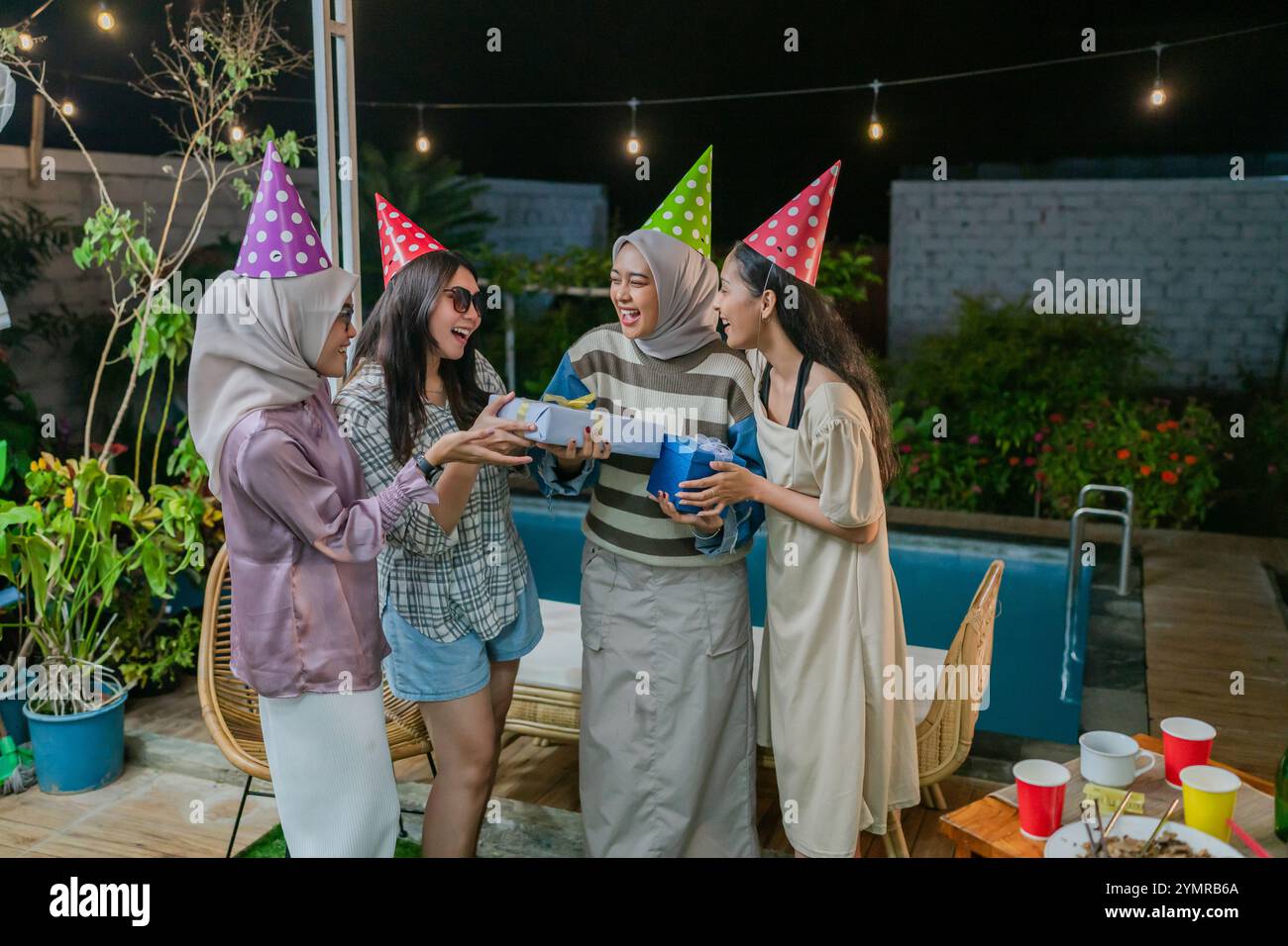 Cheerful friends celebrate joyfully, wearing party hats and embodying ...