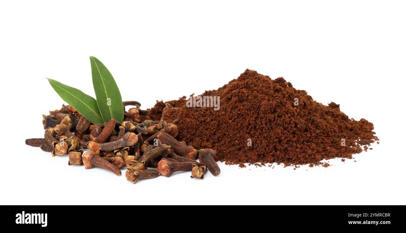 Pile of clove powder, dried buds and green leaves on white background ...