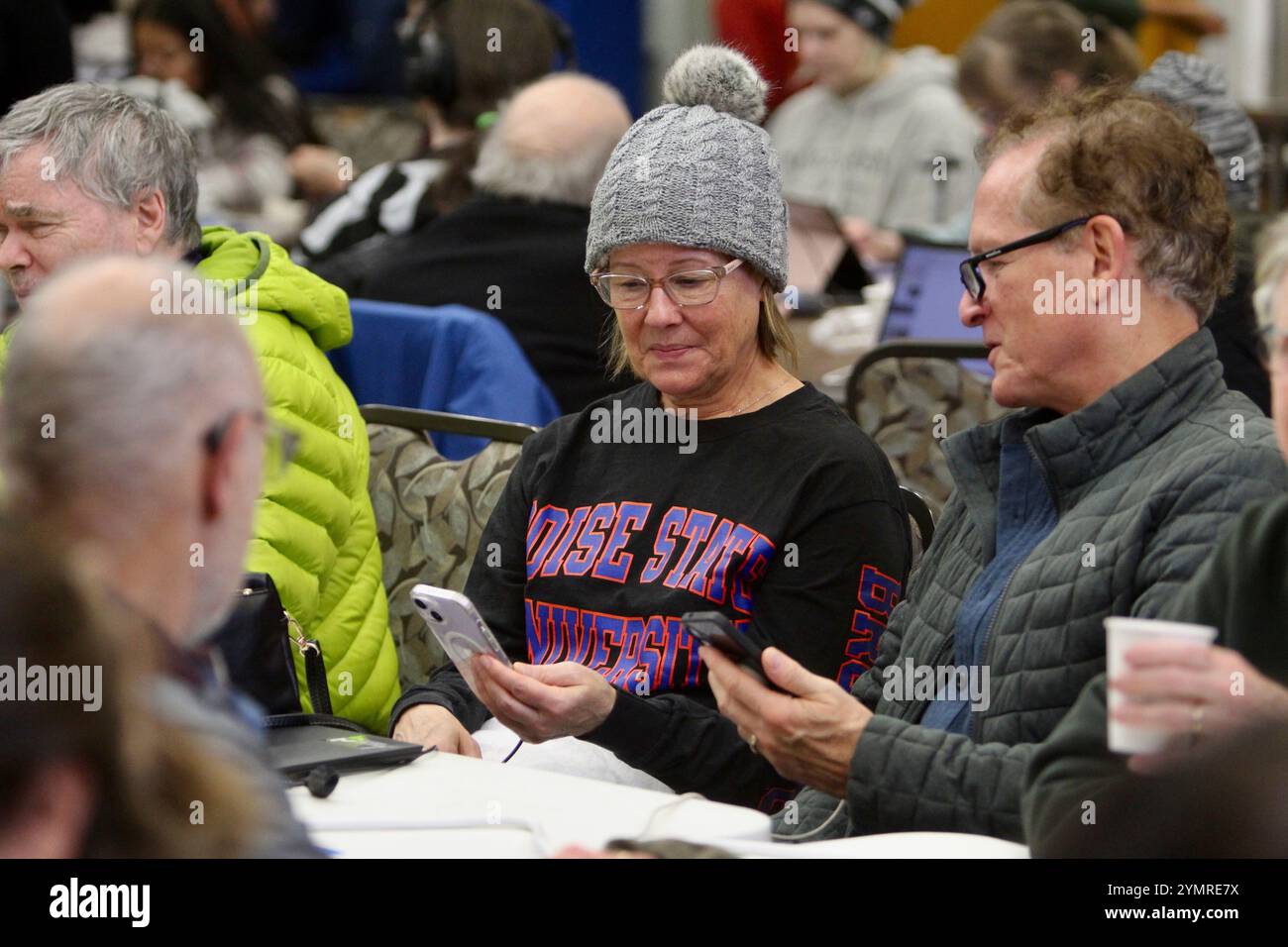 Linda Ryall and Todd Nielsen look at each other's phones at a charging ...