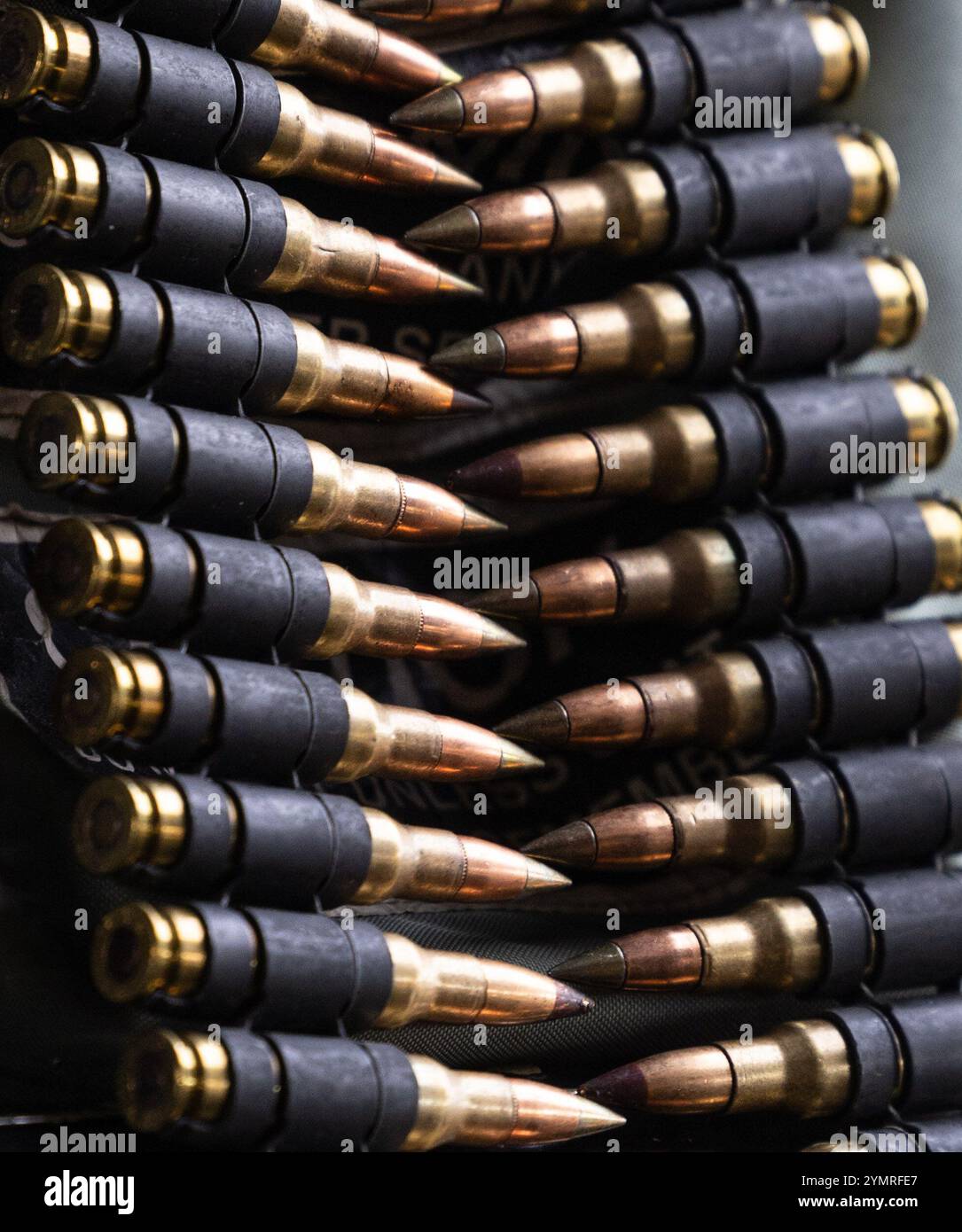 A row of 7.62mm rounds are draped over a bandolier container before ...