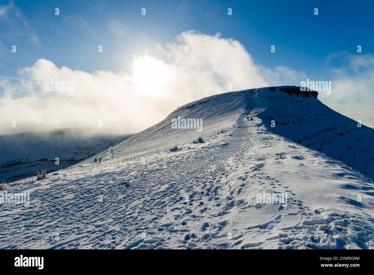 Hikers ascending a snow covered Corn Du in the Brecon Beacons Stock ...