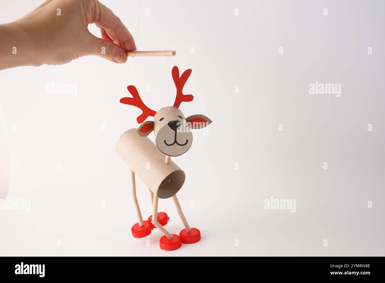 DIY reindeer puppet made from cardboard tubes, red plastic caps, and ...