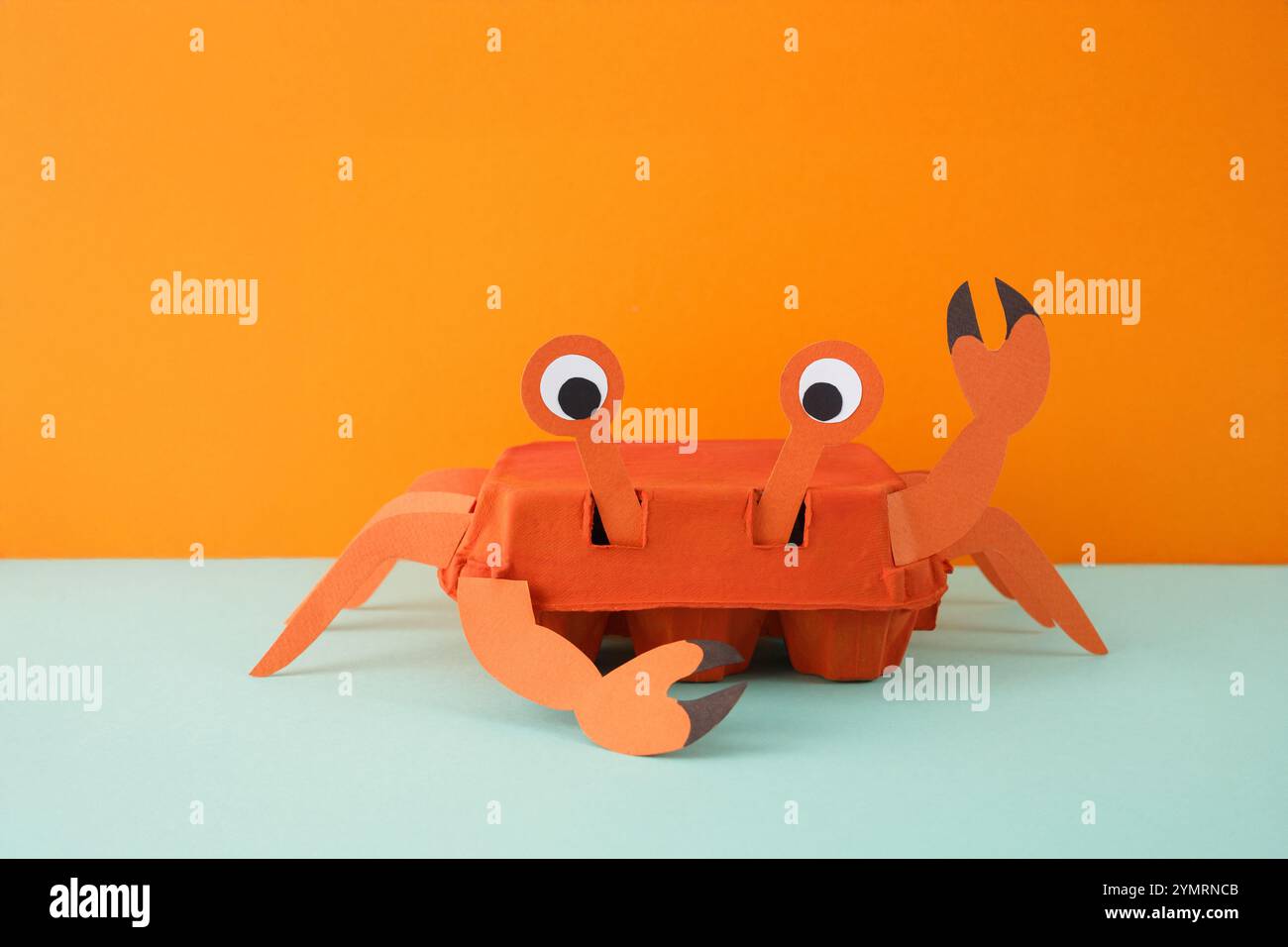 DIY crab craft made from orange egg carton with paper claws, legs, and ...