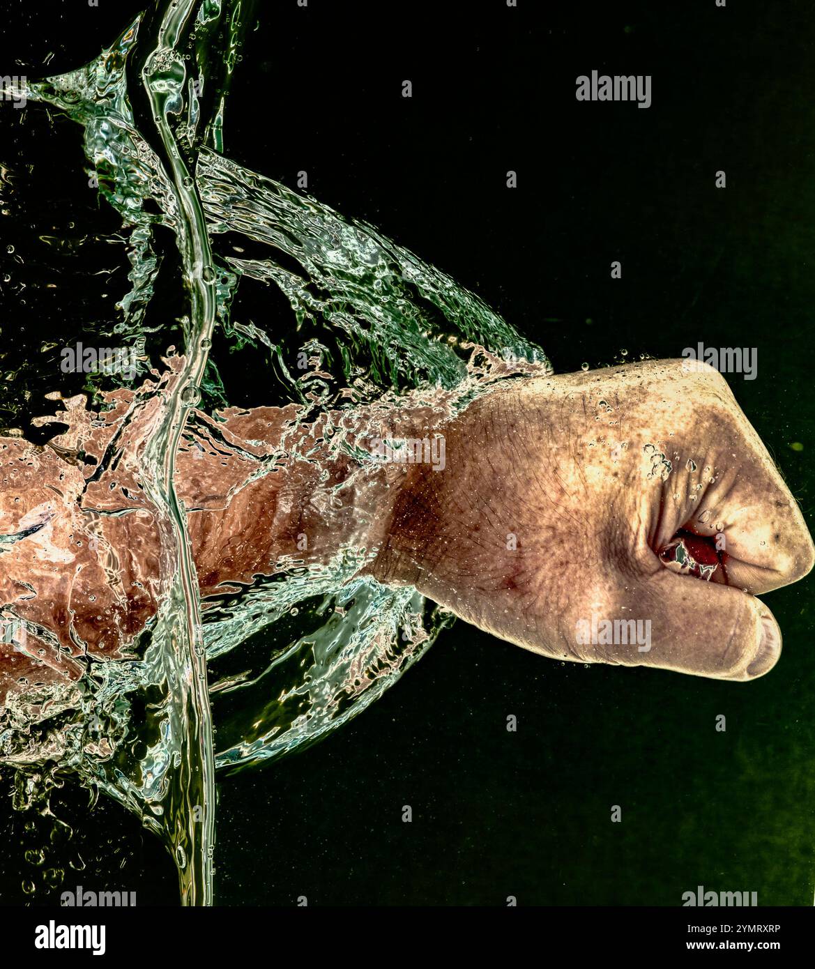 Hand punching through water surface creating splashing drops, dynamic ...