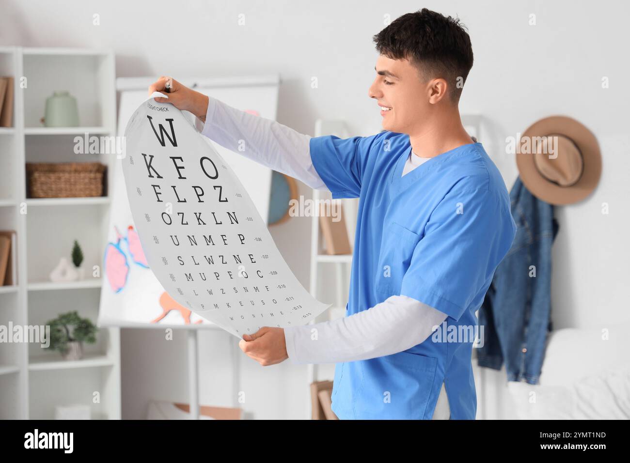 Male medical student with eye test poster at home Stock Photo - Alamy