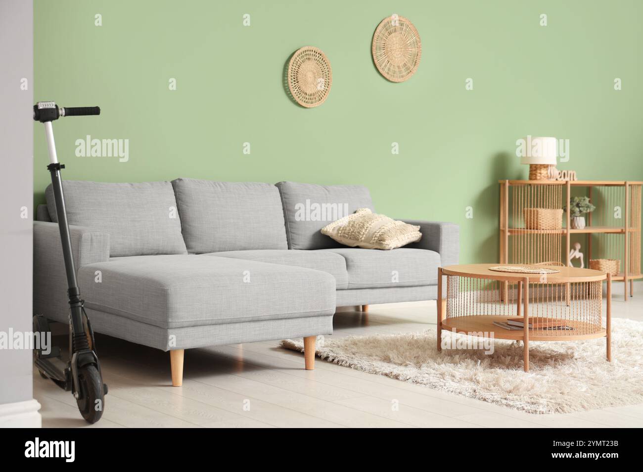 Interior of living room with electric scooter, sofa and table Stock ...