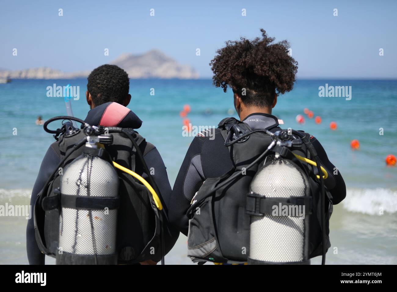 Two French tourists prepare to dive on the beach at Aegiali, Amorgos ...