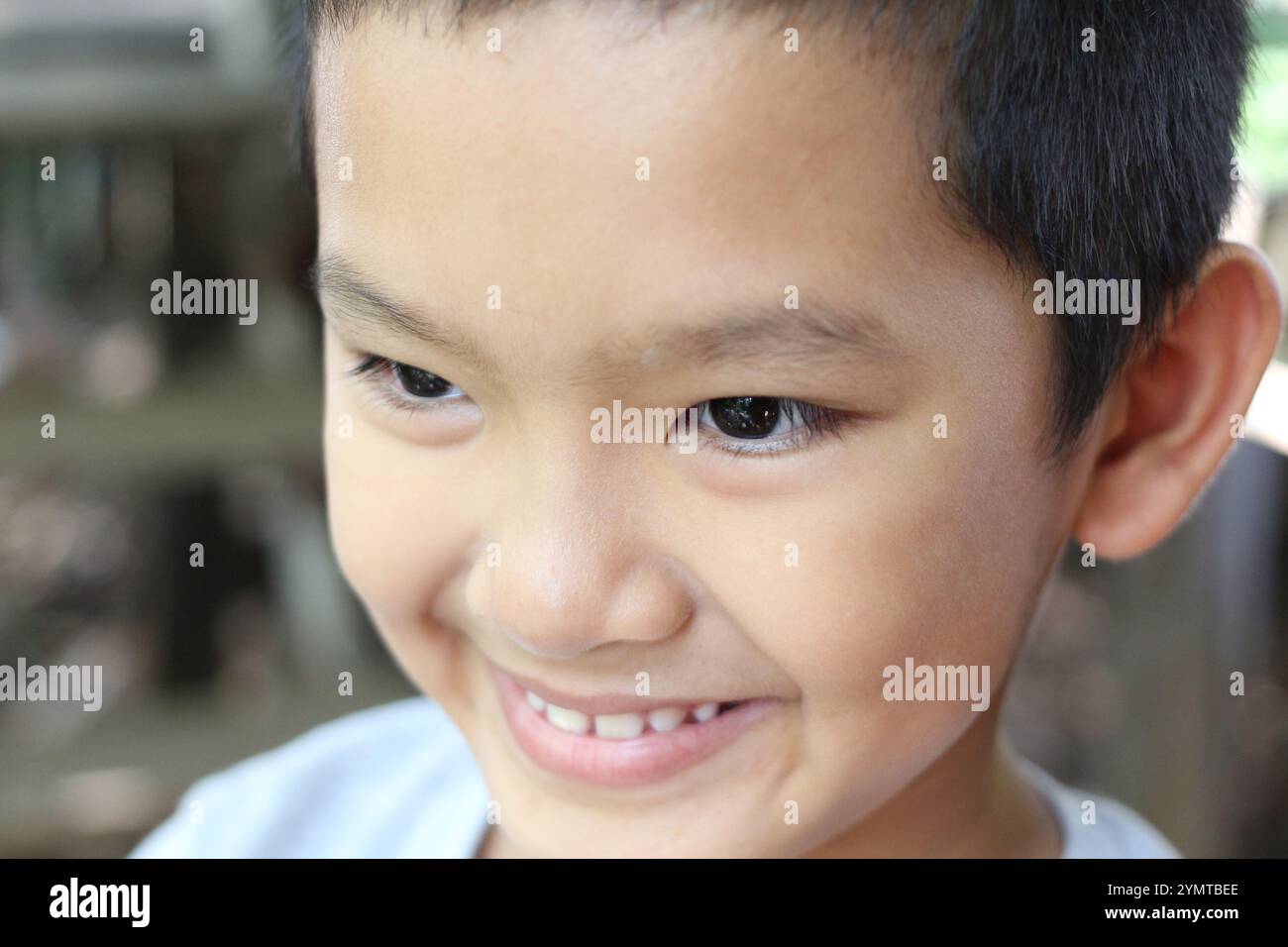 This close-up image captures a happy child with a bright smile ...
