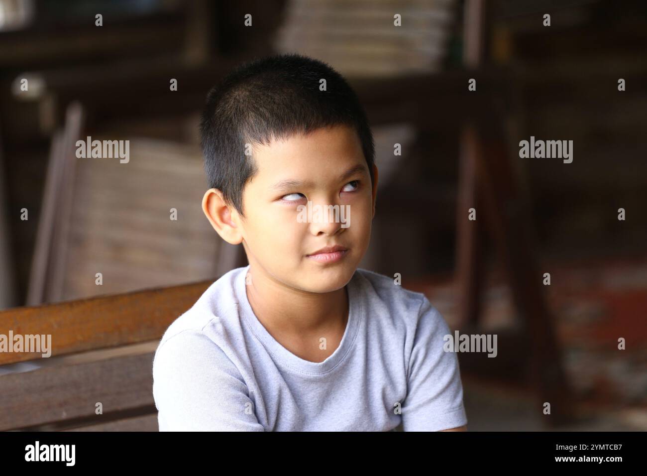 A playful boy displays a unique expression, showcasing his curiosity ...