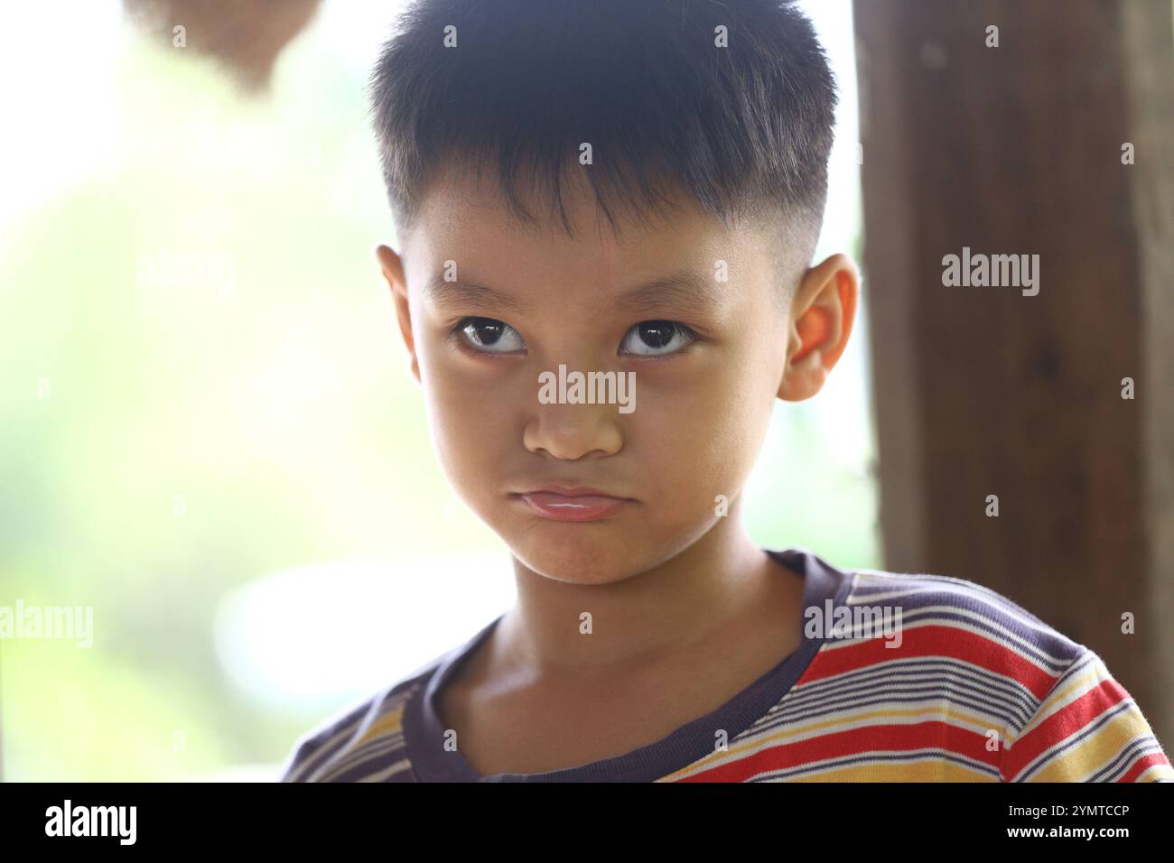 A young boy displays an intense gaze, capturing a moment of curiosity ...