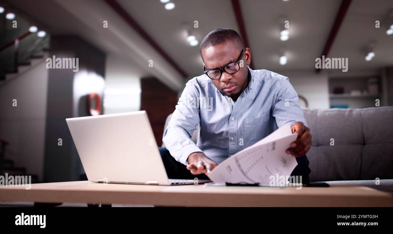 Young African Man Calculating Invoice With Calculator Stock Photo - Alamy