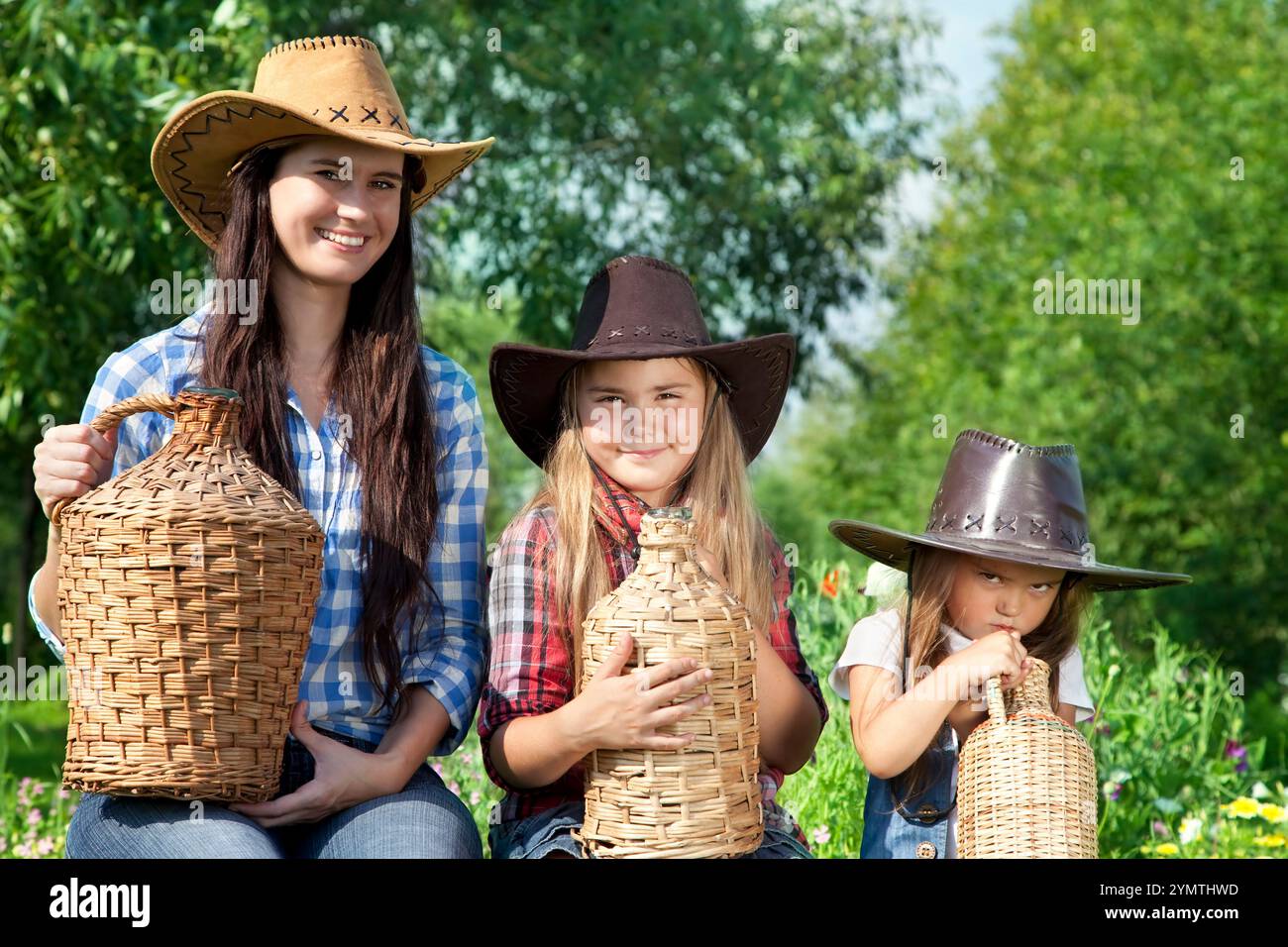 Portrait of three Caucasian girls in cowboy hats in a garden Stock ...