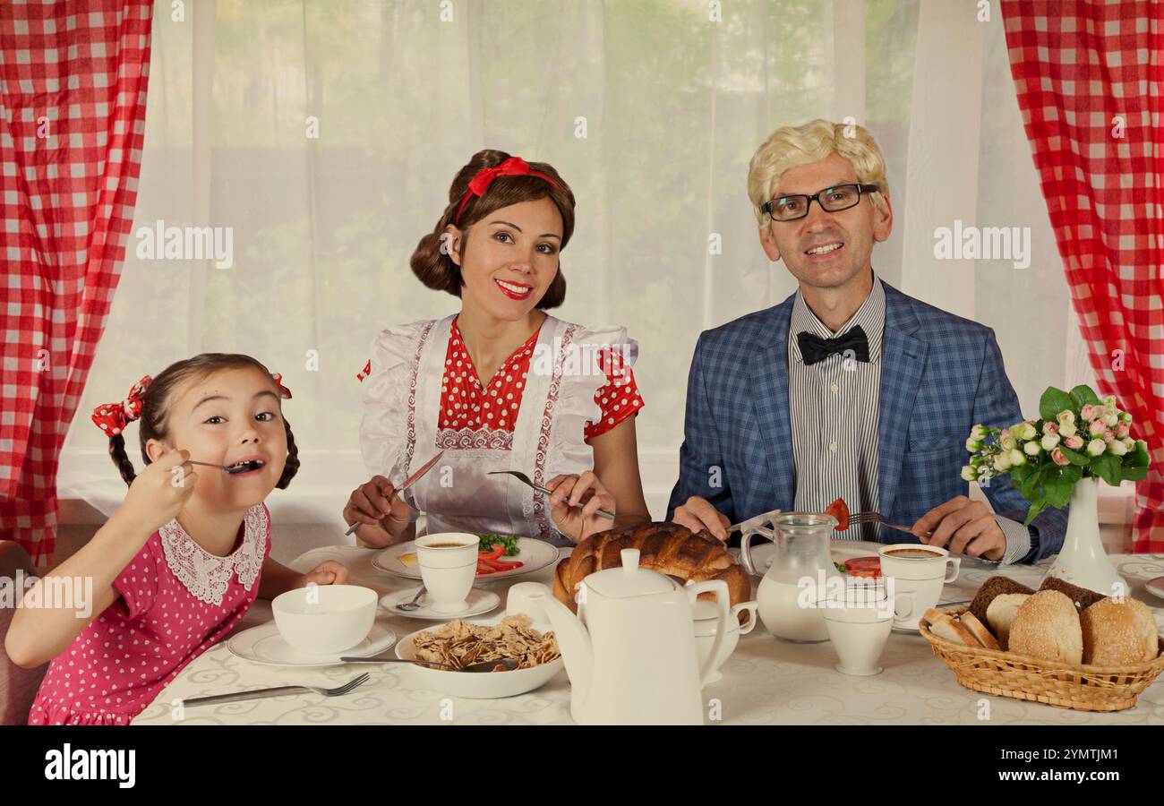 Retro styled family sitting at the table while have breakfast ...