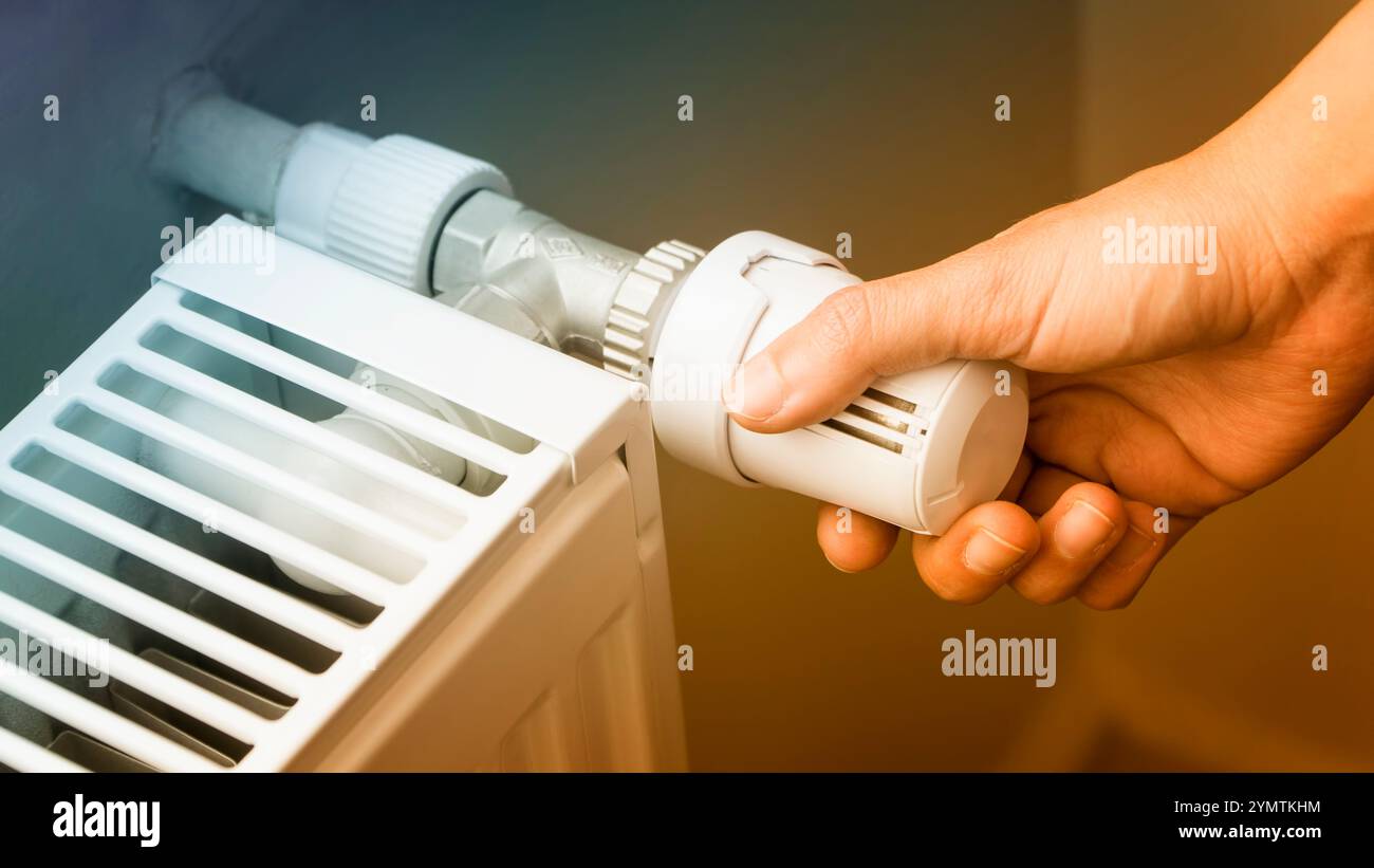 Hand Adjusting The Temperature Of A Heating Radiator Stock Photo - Alamy