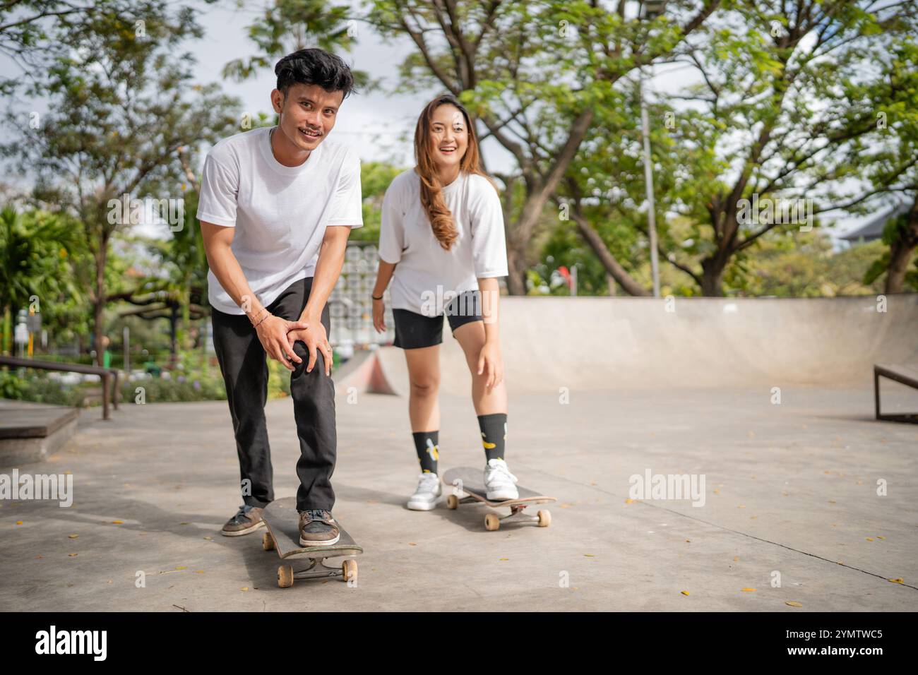 Two close friends are having a great time skateboarding together at a ...