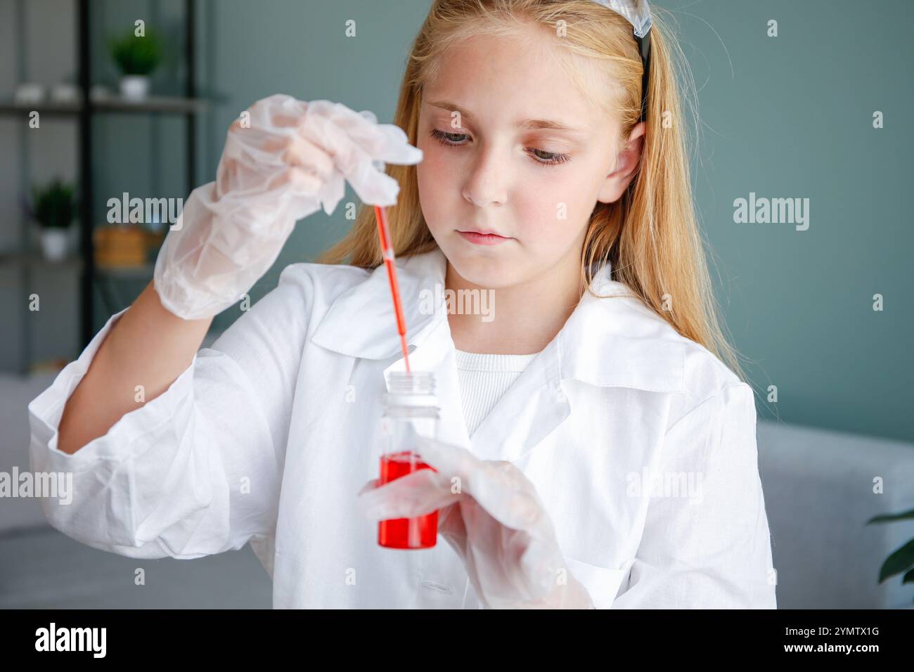 The girl conducts chemical experiments at home. The focus is on the ...
