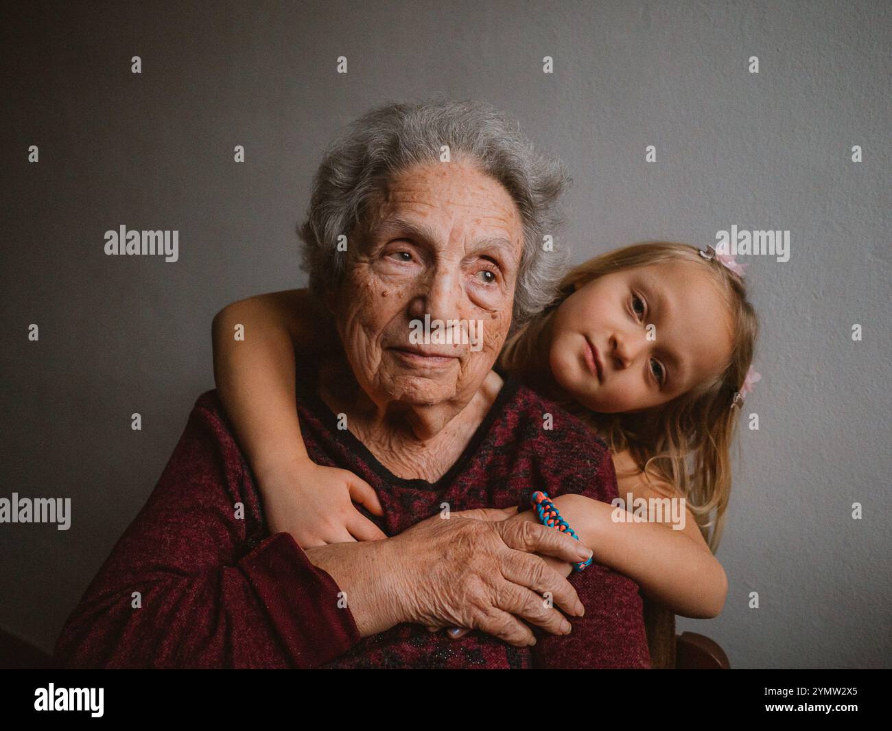 Elderly woman and great-grandchild sharing a tender moment ...