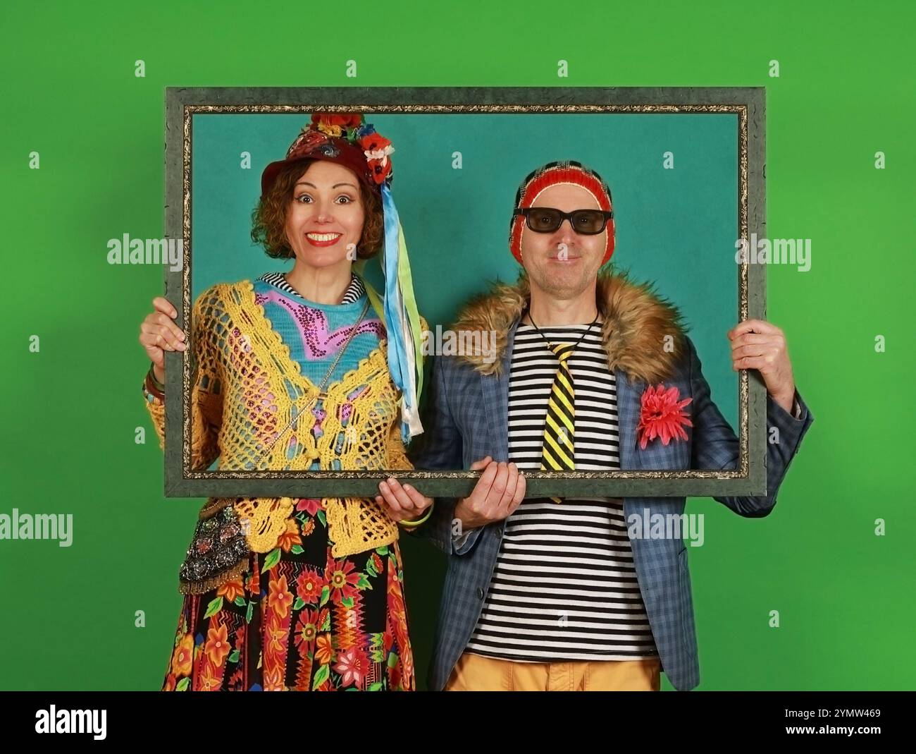 Funny freaky couple posing in the studio holding a picture frame in ...