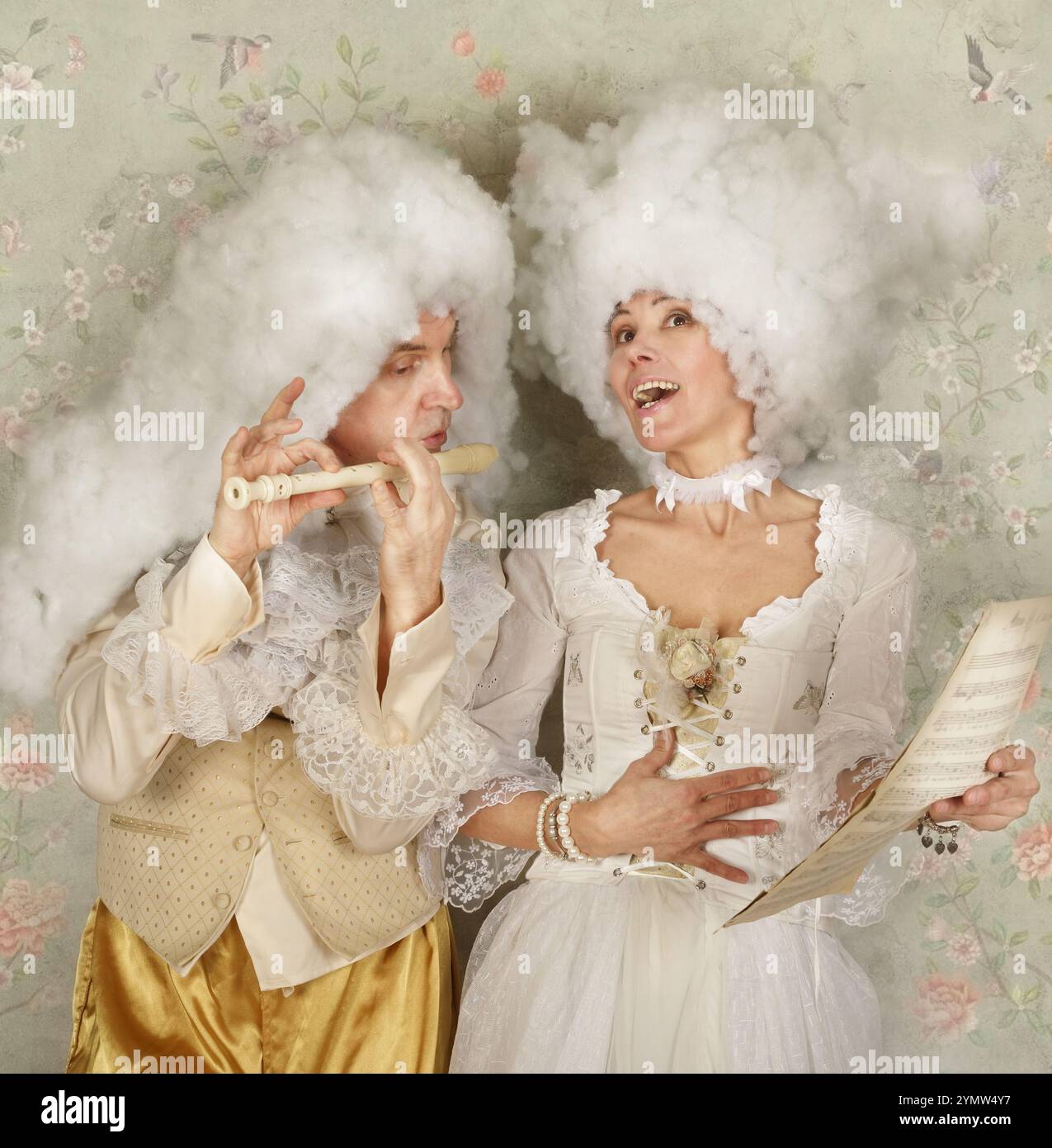 Cute couple in Baroque style clothes, a man playing a flute, a lady ...