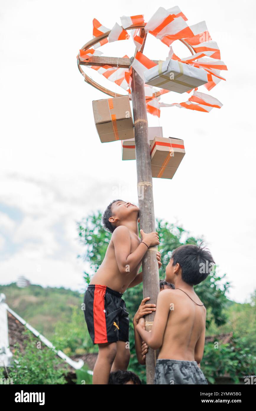 climbing child looks up at the hanging prize while holding Stock Photo ...