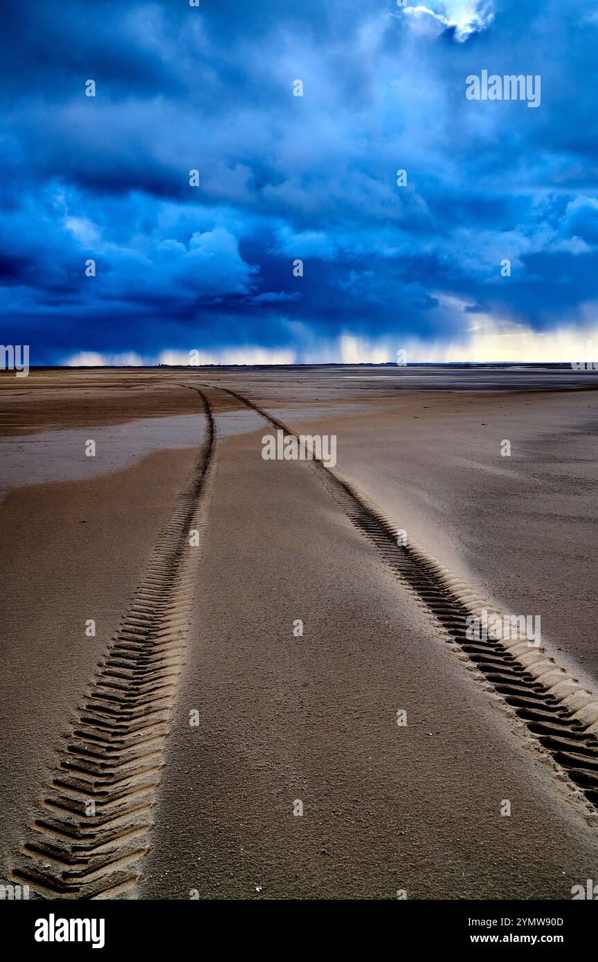 Tyre tracks heading into Storm Bert approaching from over the irish Sea ...