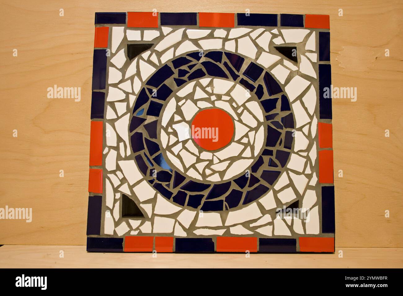 A roundel mosaic made using ceramic tiles, tile grout and plywood. The ...