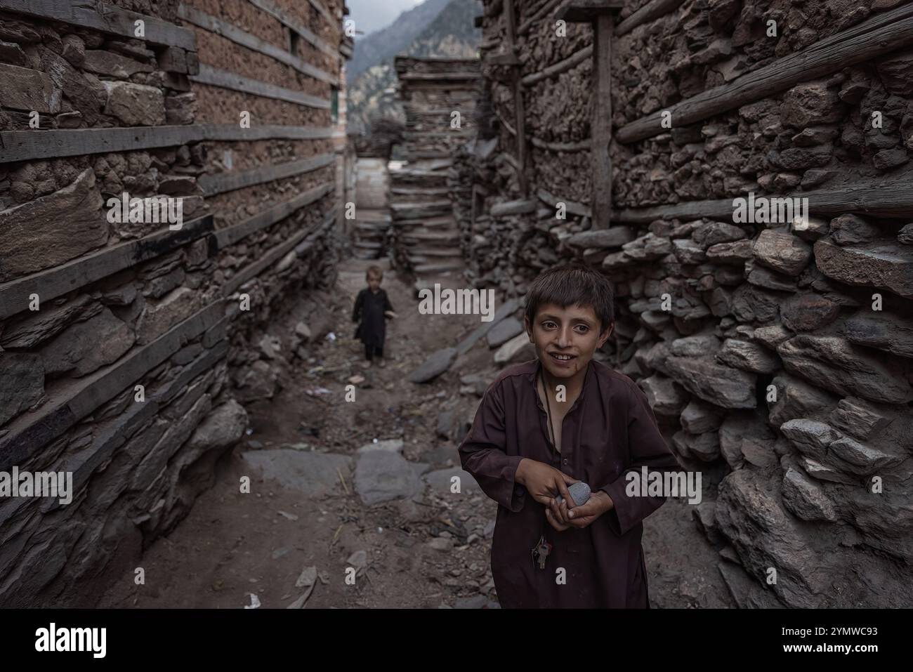 Two children walking through the oldest alleys of Nuristan, which hold ...