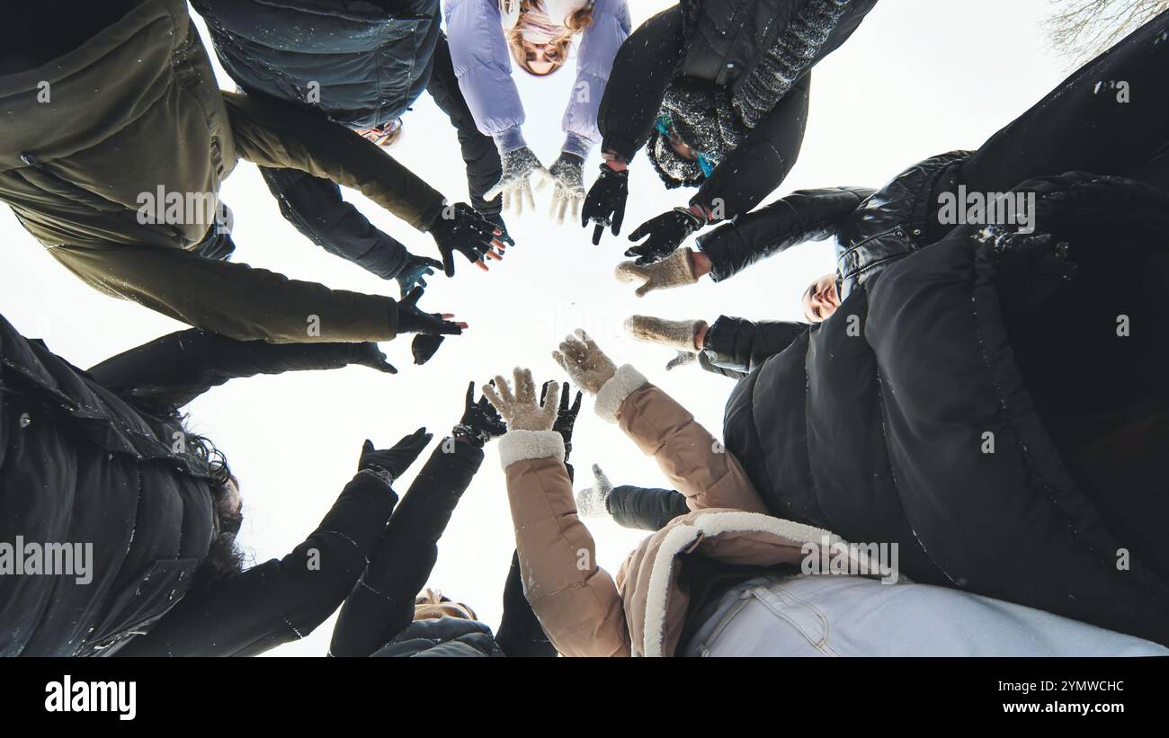 Schoolgirls wearing winter clothes and gloves, forming a circle with ...