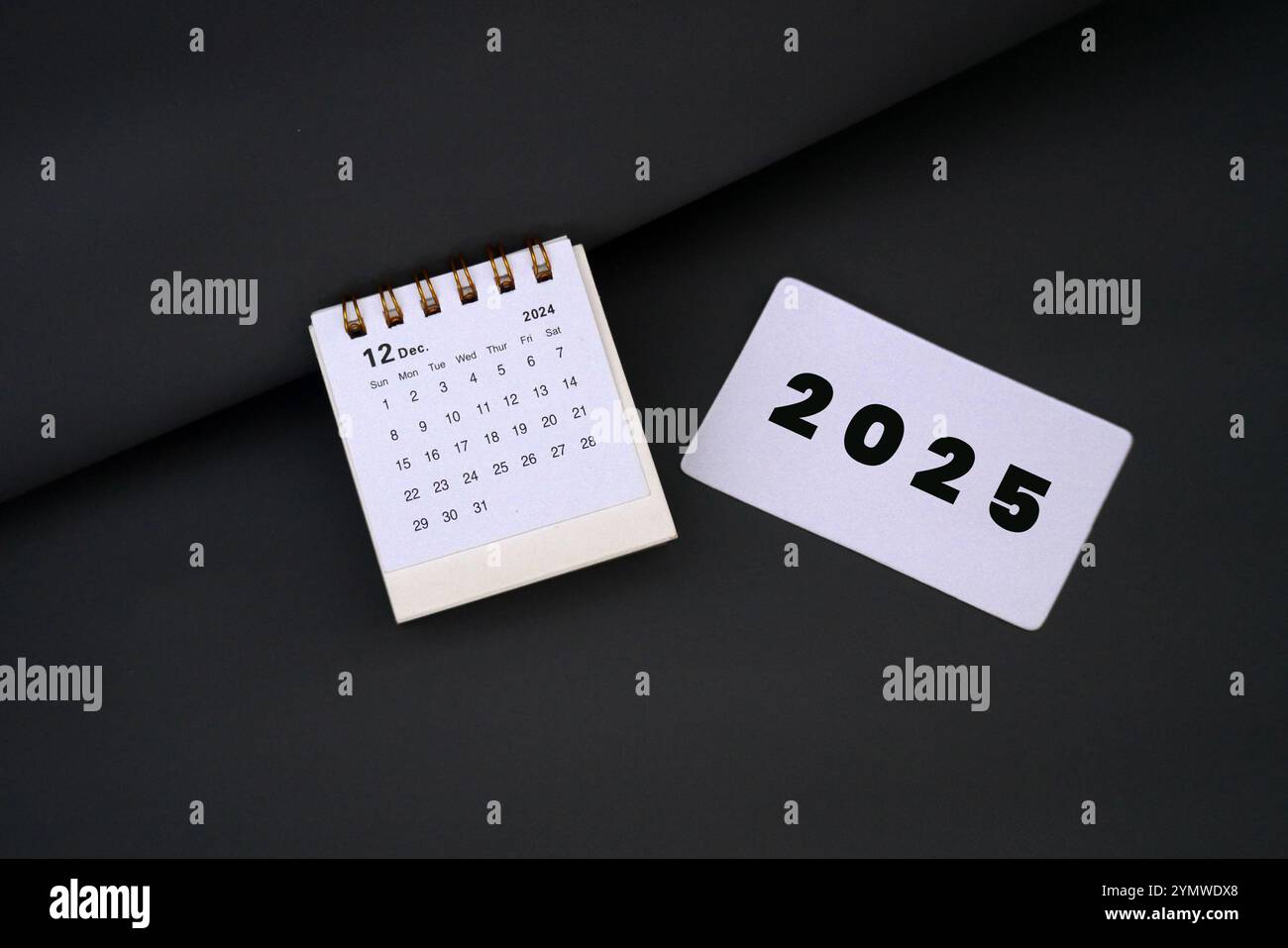 2025 card next to December 2024 desk calendar. End of year 2024 concept ...