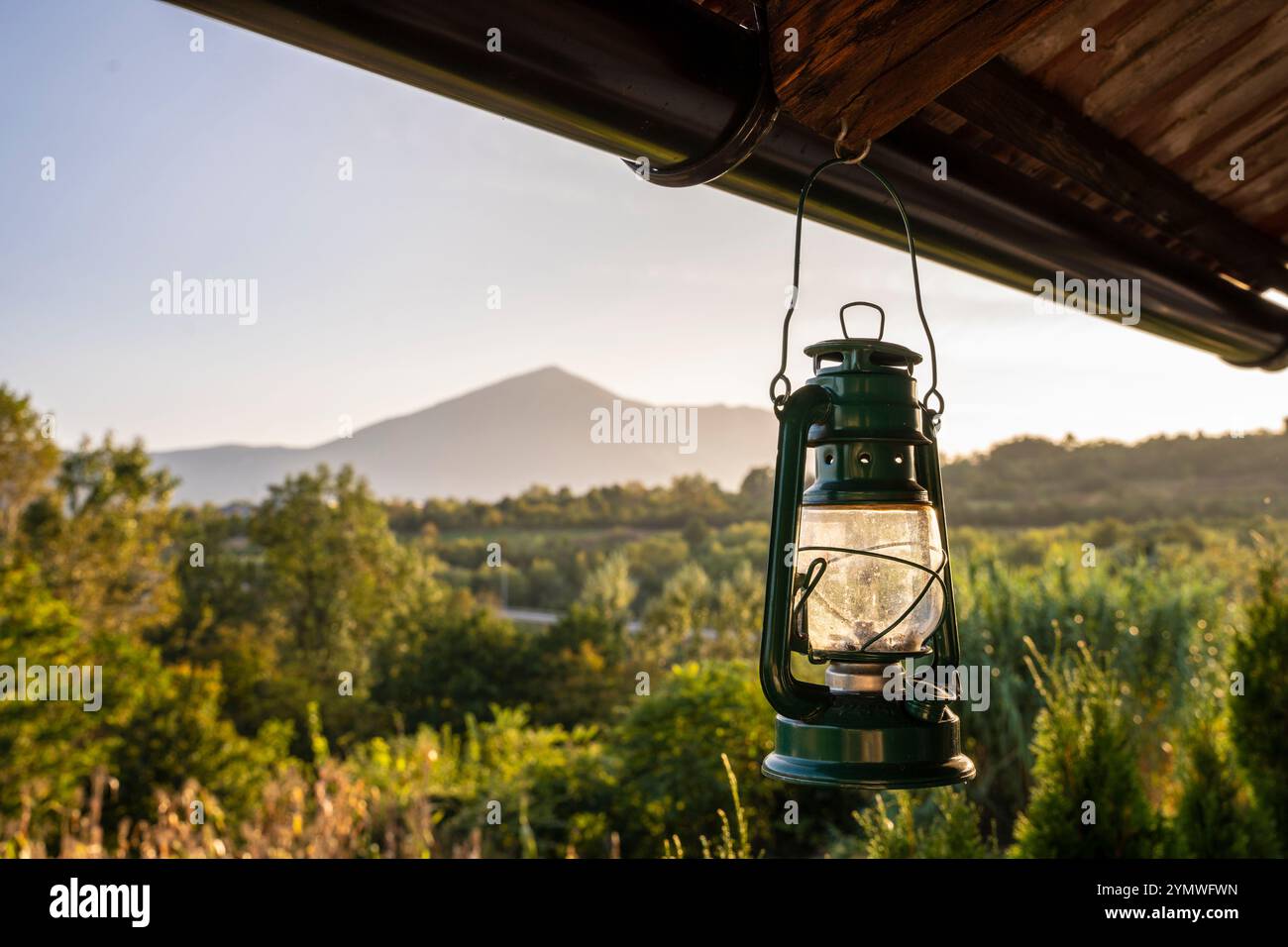 A gas lantern hanging from a roof at sunset Stock Photo - Alamy