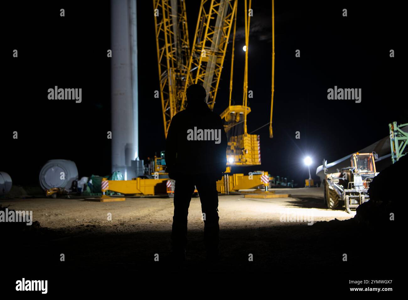 Silhouette of man standing infront of Empty construction site at night ...