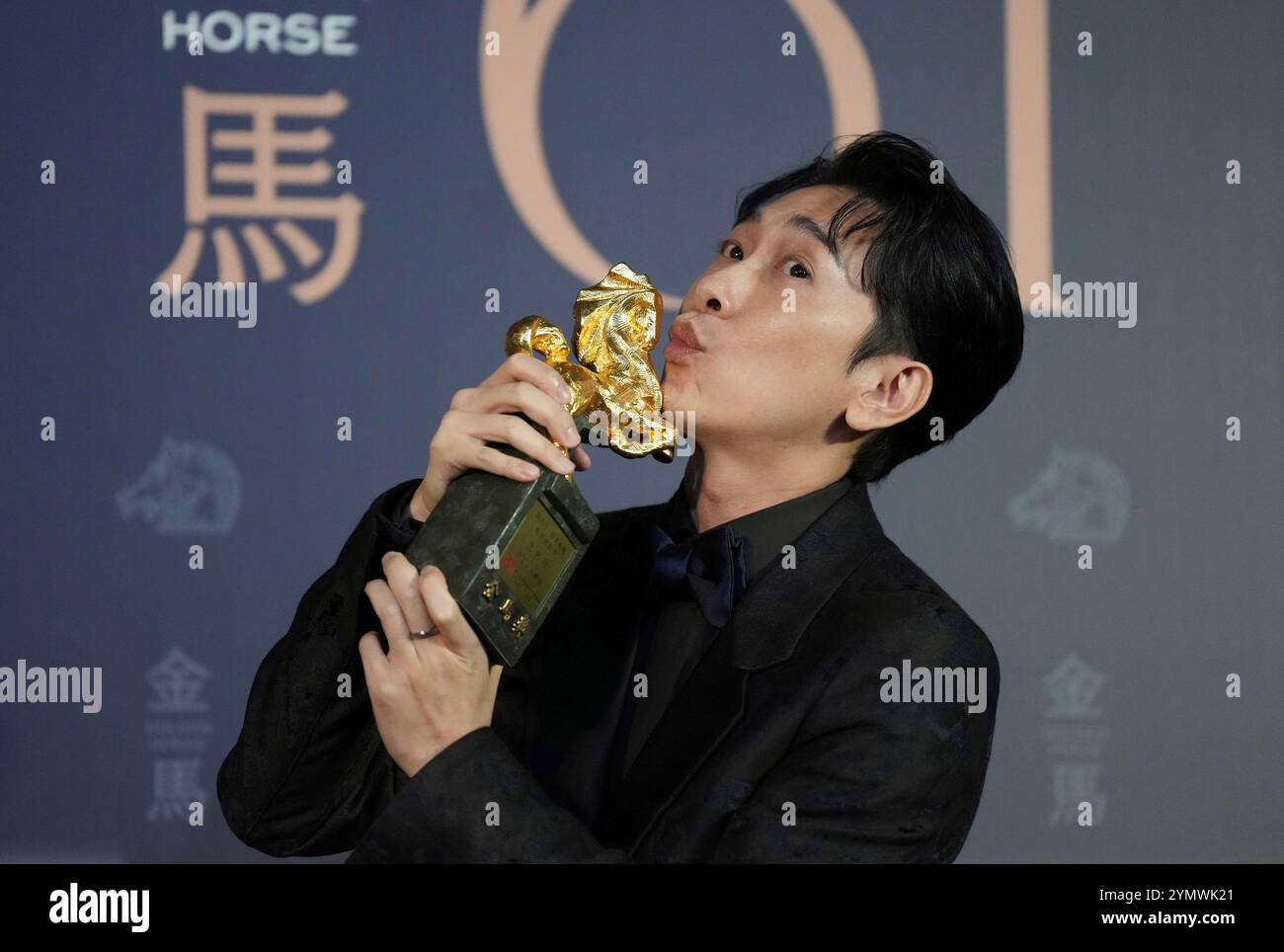 Shih Ming-shuai kisses his award for Best Supporting Actor at the 61st Golden Horse Awards in ...