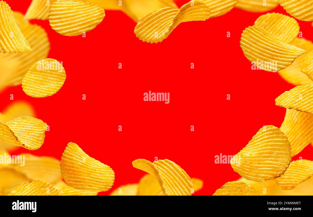 Ridged potato chips frame, red background Stock Photo - Alamy