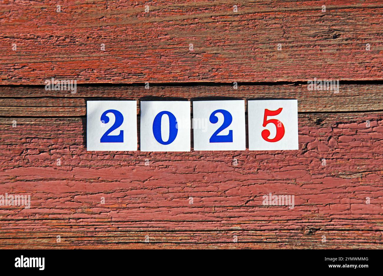 Numbers of 2025 year. Paper square numbers on the wooden fence ...