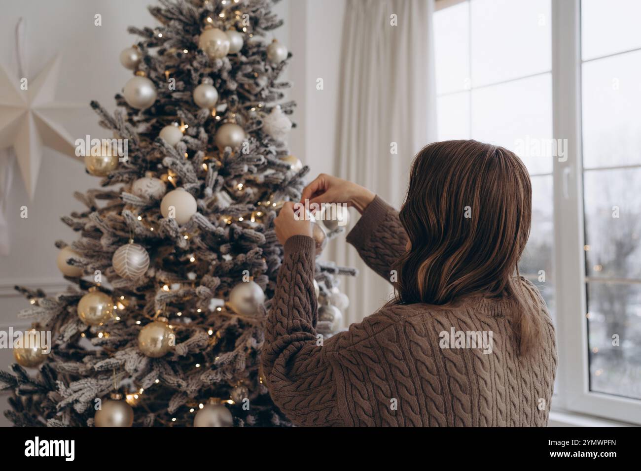 Woman decorating a Christmas tree Stock Photo - Alamy