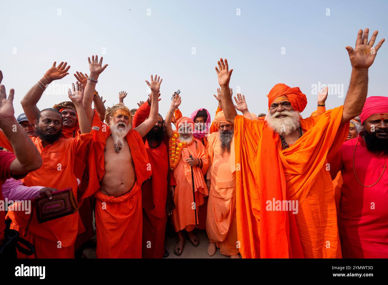 Sadhus, or Indian holy men, raise their hands during the Mahakumbh ...