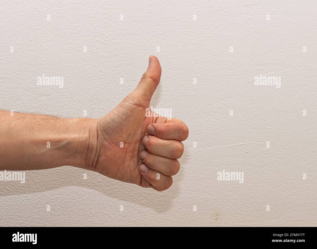Detail of a Caucasian male's hand showing approval with a thumbs up ...