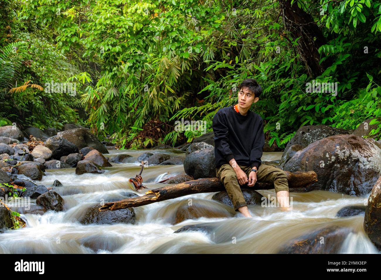 Man sitting on the river while looking around Stock Photo - Alamy