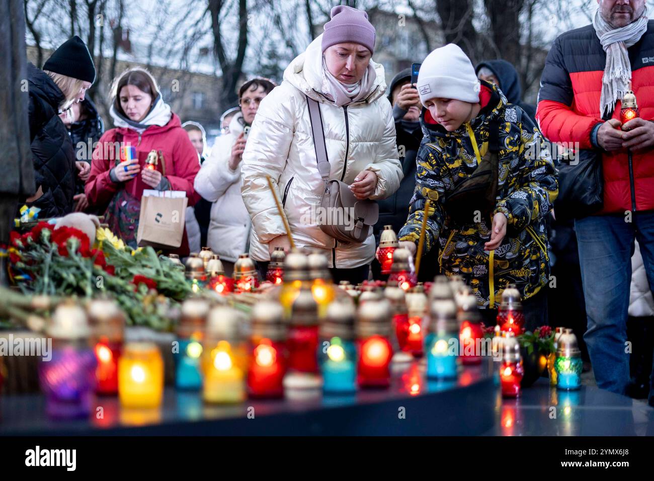 Kyiv, Ukraine. 24th Nov 2024. Young boy seen placing down candles at ...