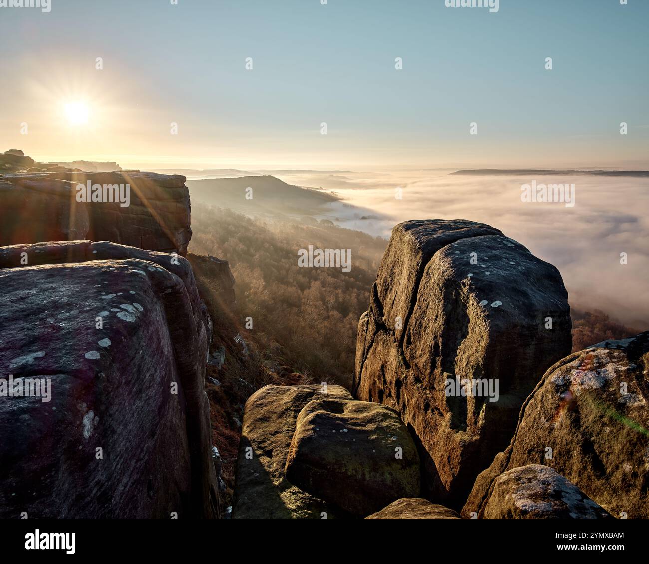 Sunrise over a cloud inversion seen over dramatic rocks on Curbar Edge ...