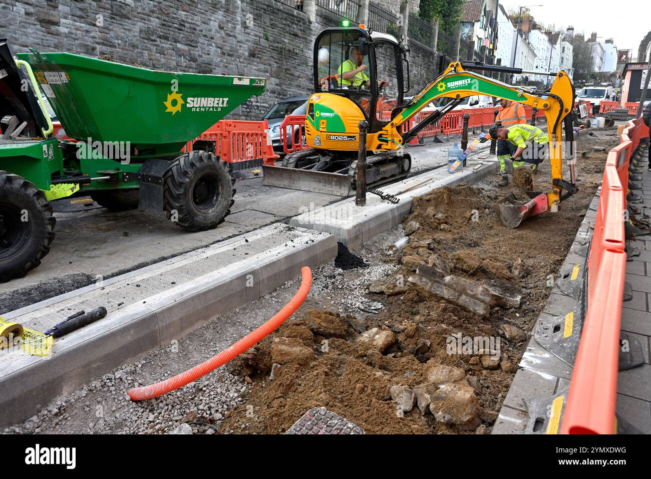 Roadworks with machinery building new dedicated cycle lane to separate ...