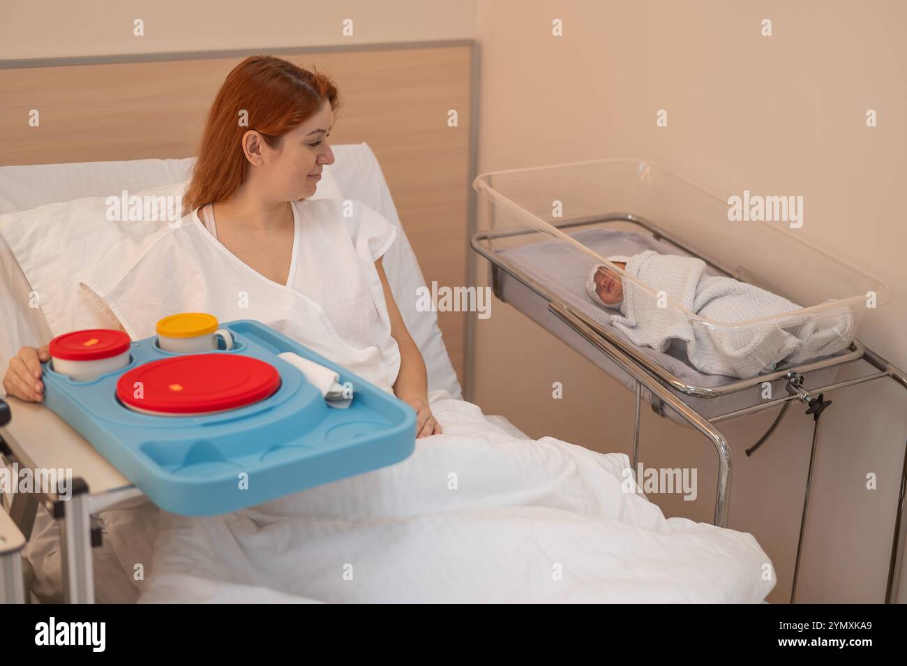 Caucasian woman eats on hospital bed after giving birth Stock Photo - Alamy