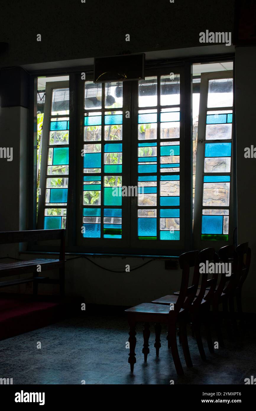 Ancient windows with stained glass, little light enters the room and ...