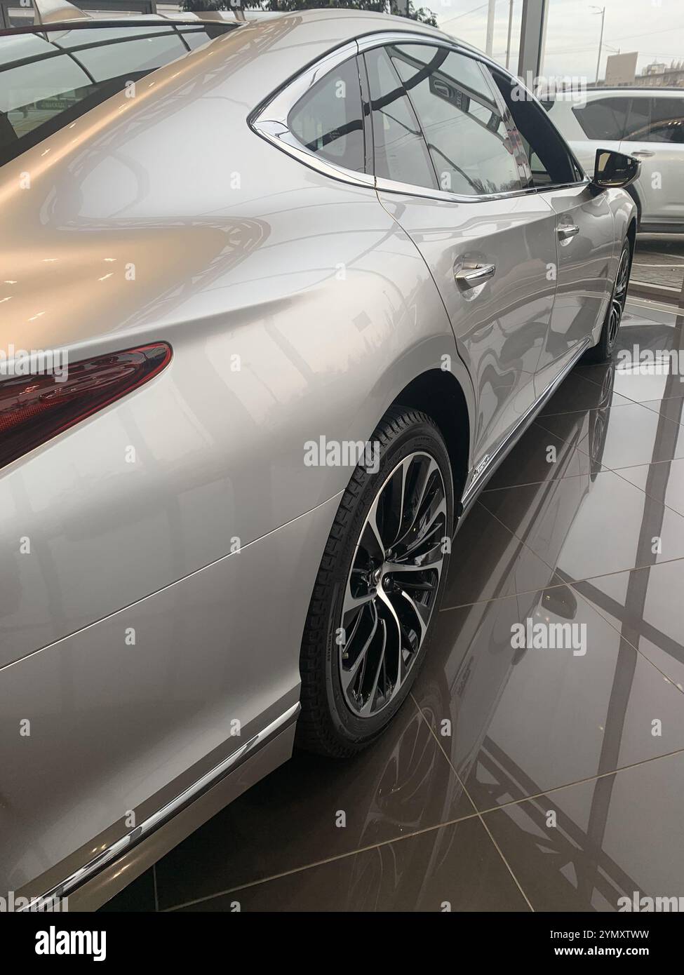 A shiny silver luxury sedan with distinctive alloy wheels, showcased in ...