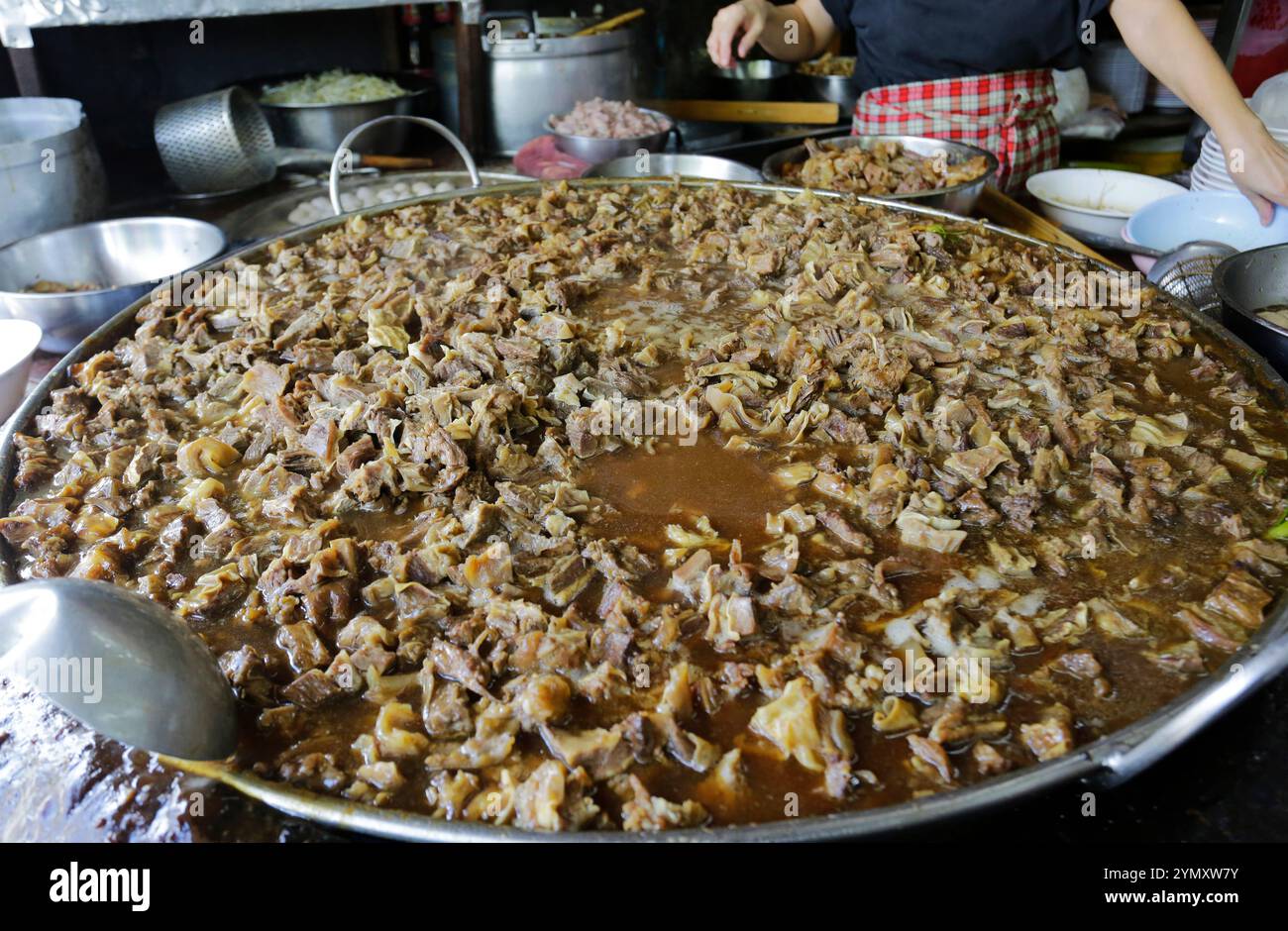 A giant pan full of stewed beef and goat meat is seen in a Chinese ...